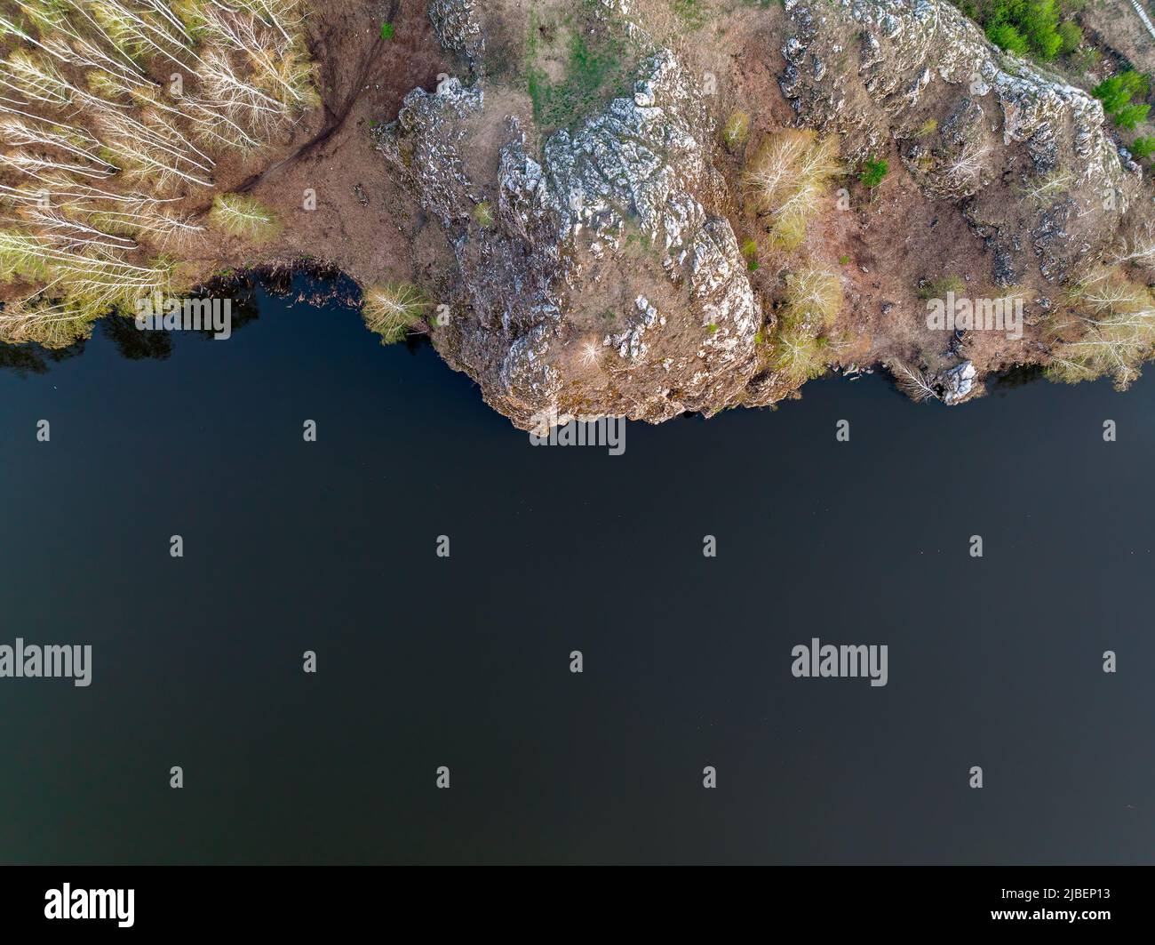Aerial view of river shore with rocks and forest. Spring or autumn ...