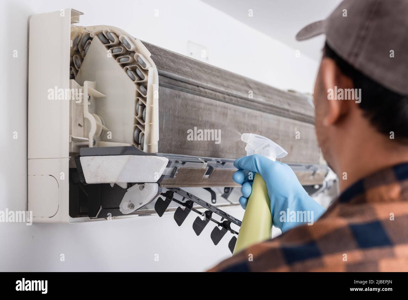 The man cleaning air conditioner indoor unit. Maintaining the air ...