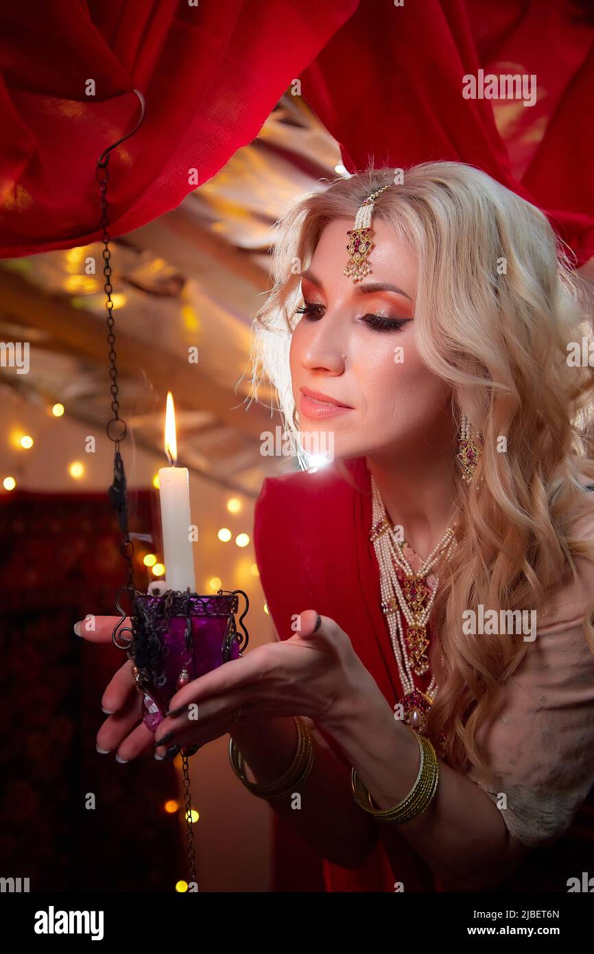 Beautiful European girl looking like an Arab woman in a red room in a ...