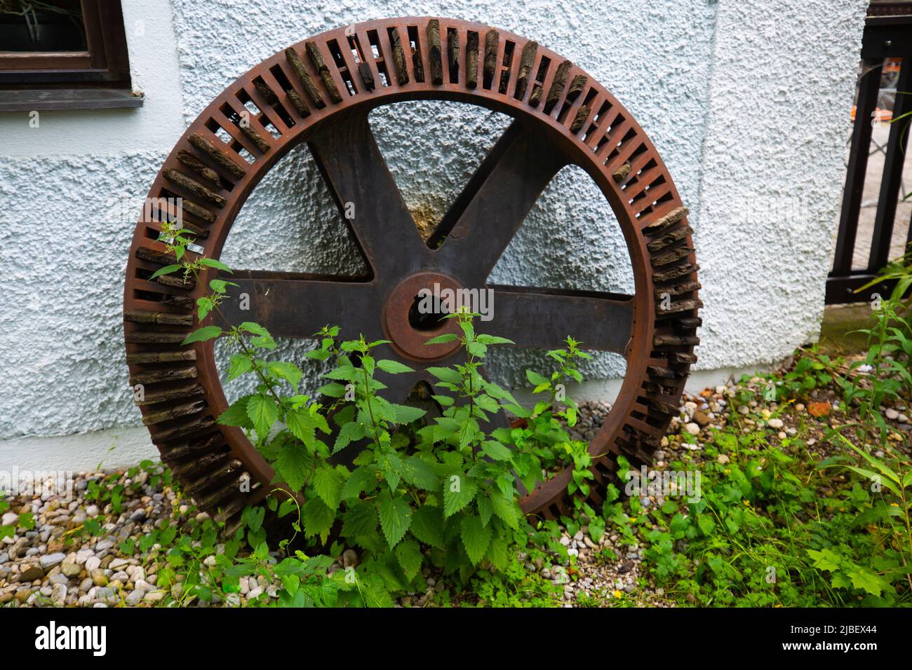 Mill wheel leaning against the house wall Stock Photo - Alamy