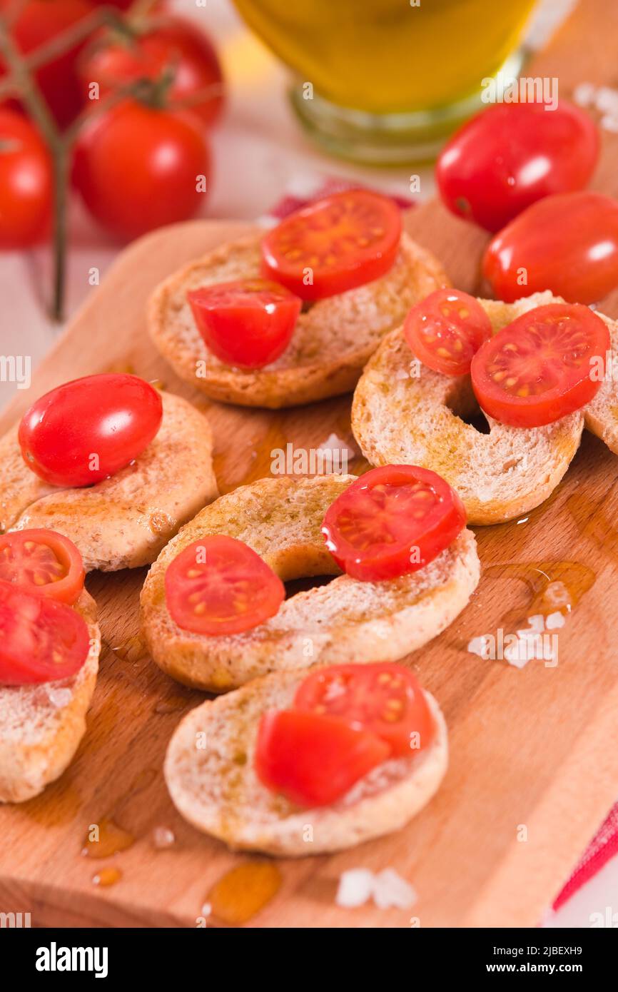 Friselle with cherry tomatoes and olive oil Stock Photo - Alamy