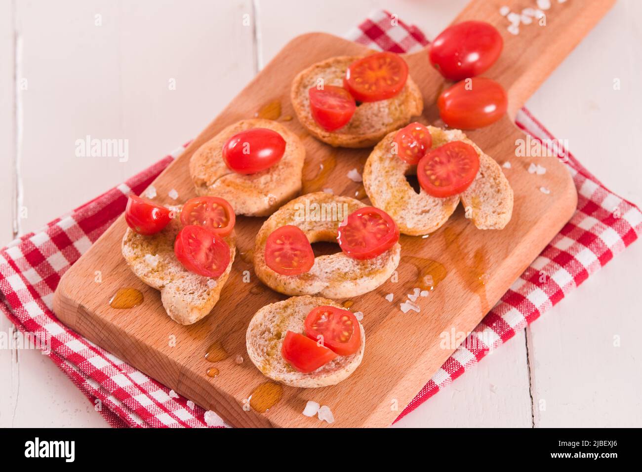 Friselle with cherry tomatoes and olive oil Stock Photo - Alamy