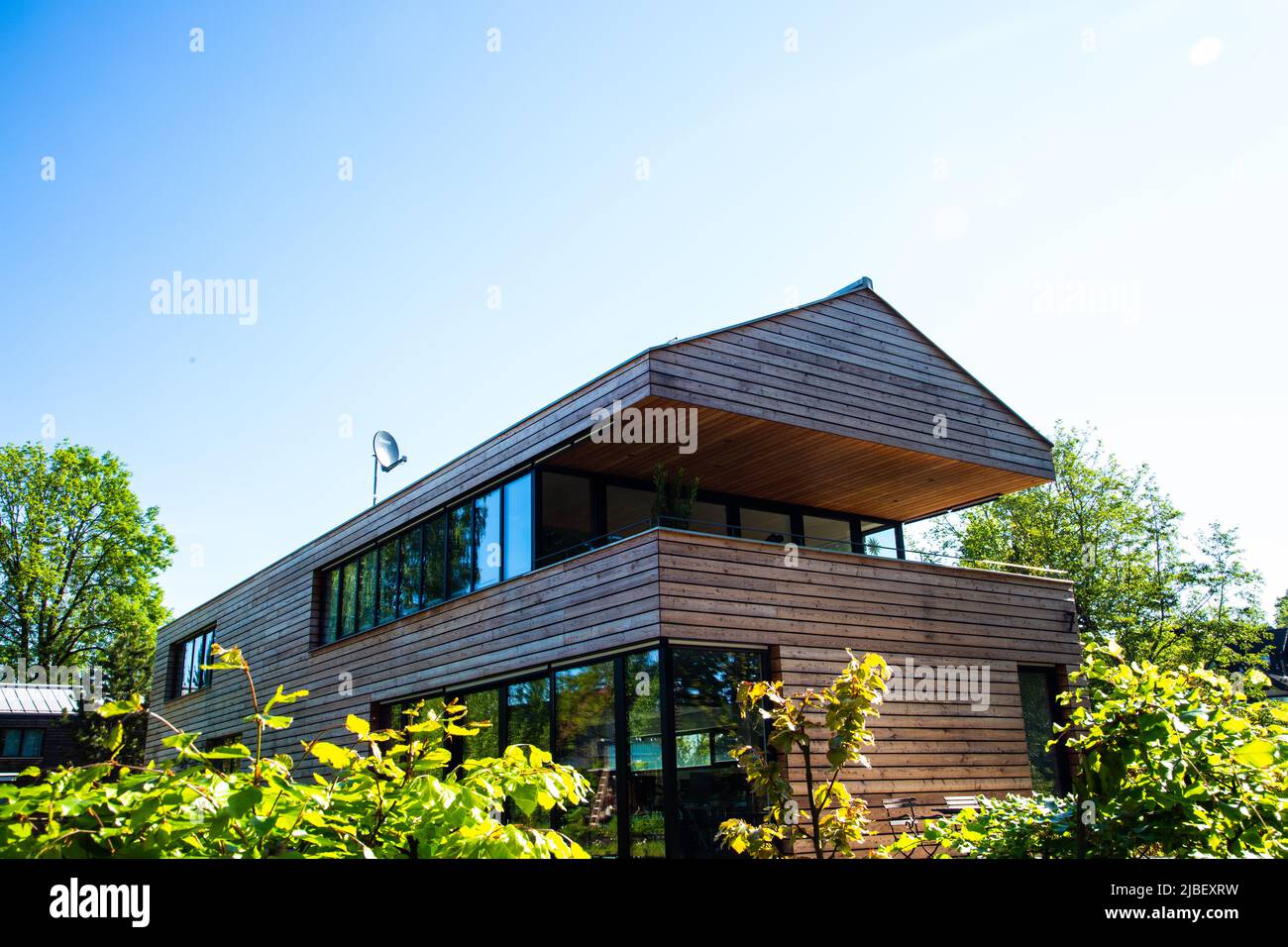 modern wooden house with blue sky, side view Stock Photo - Alamy
