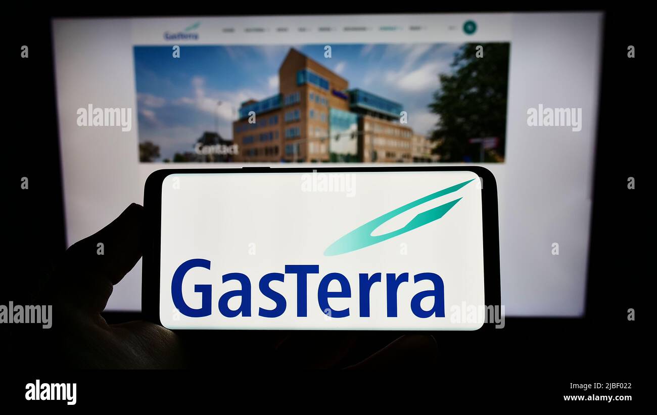 Person holding cellphone with logo of Dutch energy company GasTerra B.V ...