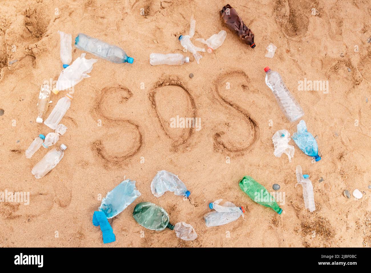 Frame from plastic dirty bottles with text SOS. Top view. The concept ...
