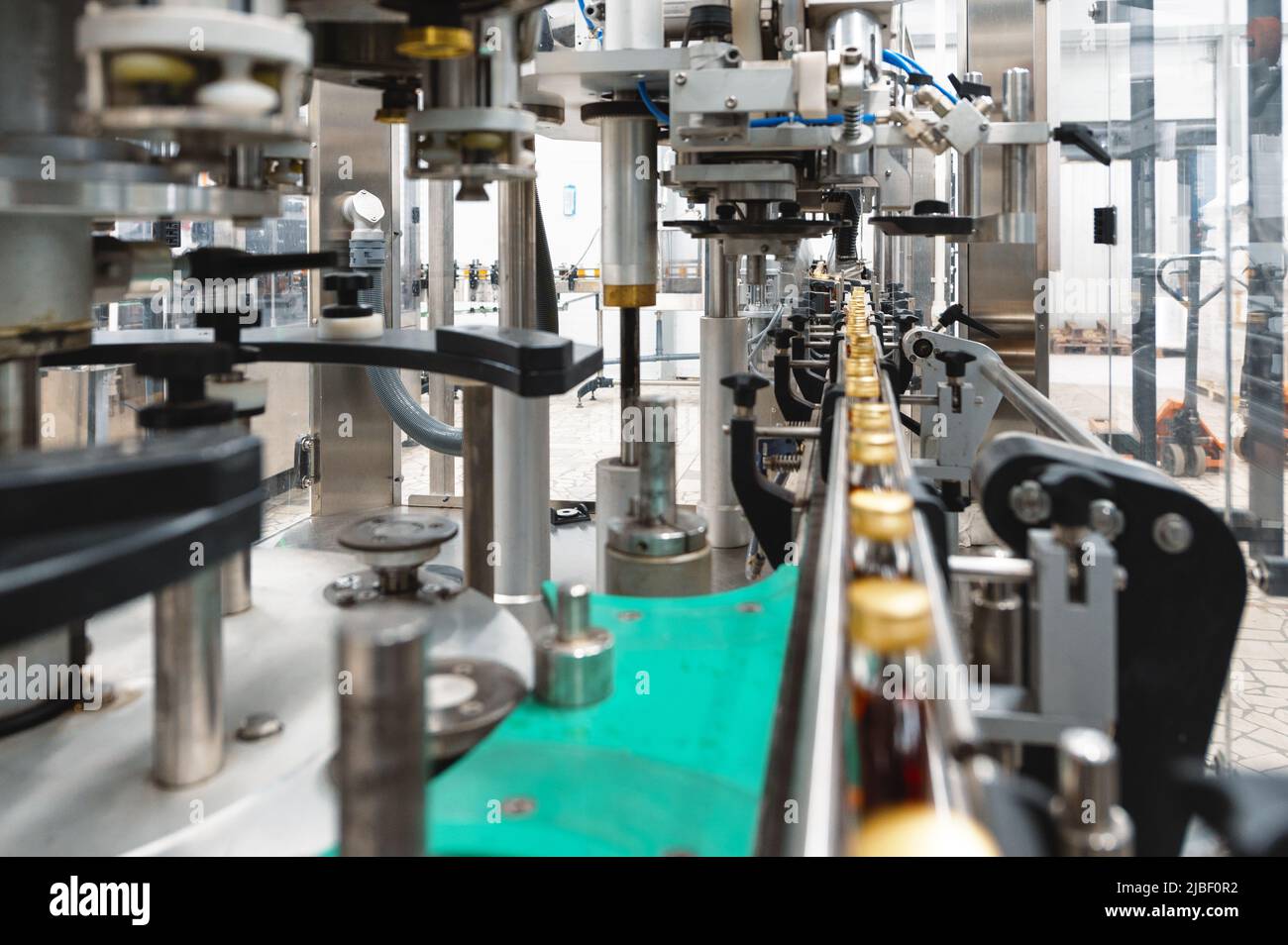 Production line transports closed bottles of yellow alcohol Stock Photo ...