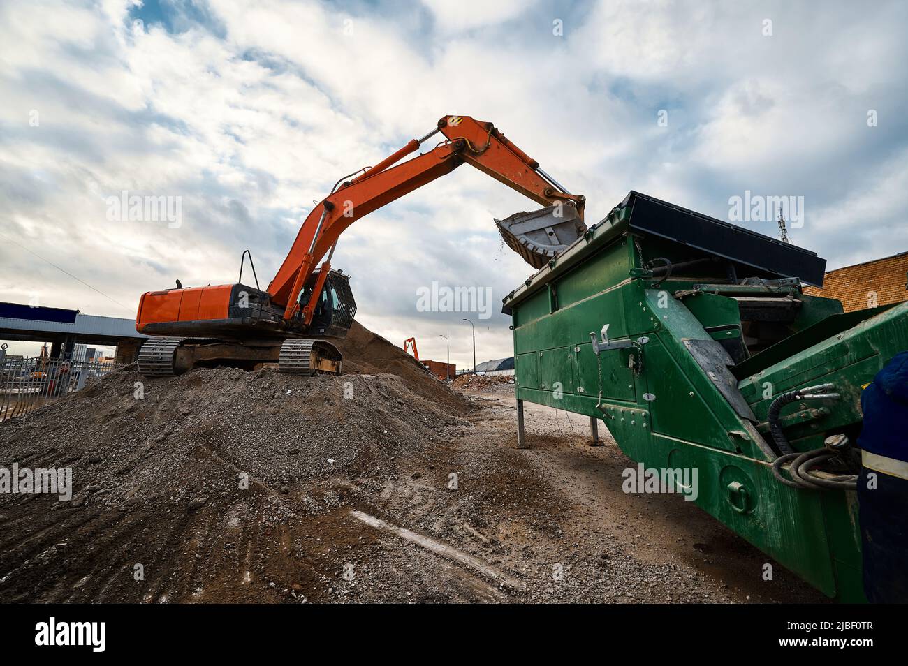Excavator loads soil in mobile crushing and sorting complex Stock Photo ...