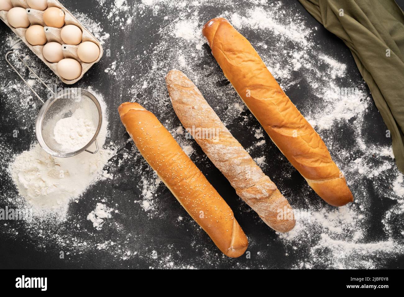 view photo of a variety of french baguette on a black board background ...