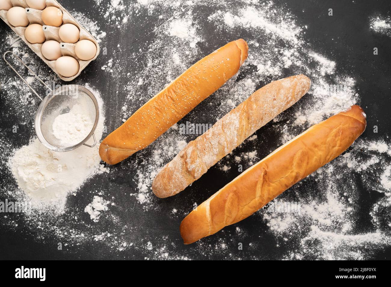 view photo of a variety of french baguette on a black board background ...
