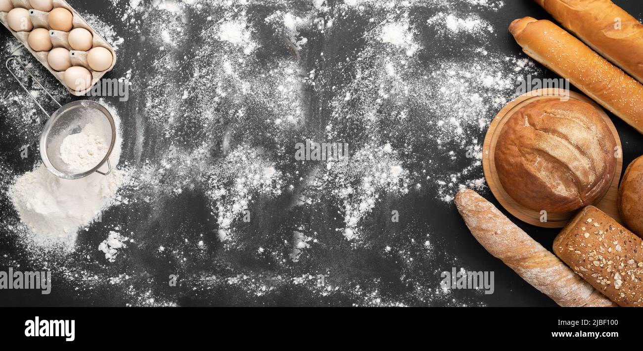 Bakery products golden rustic bread crusts and buns on a black board ...