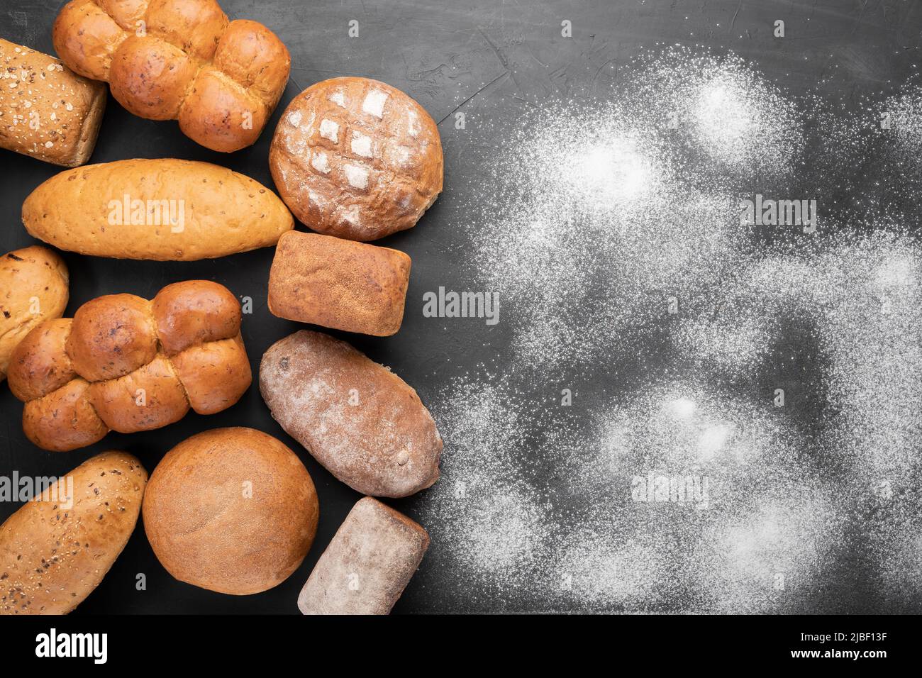 bread varios on black background with flour, wheat and rye bread with ...