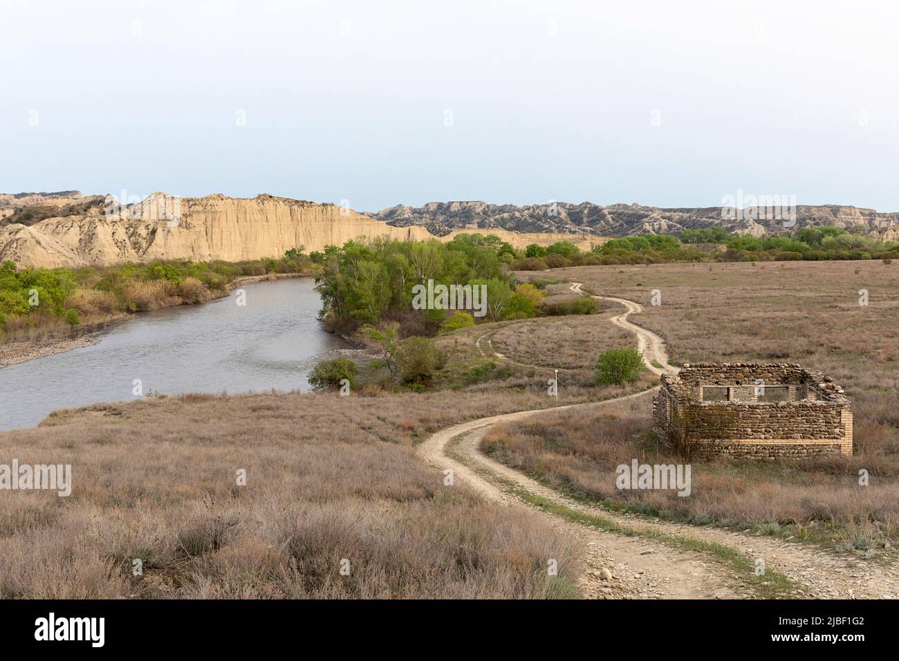 Windy gravel road and stone ruins of a house close to border Alazani ...