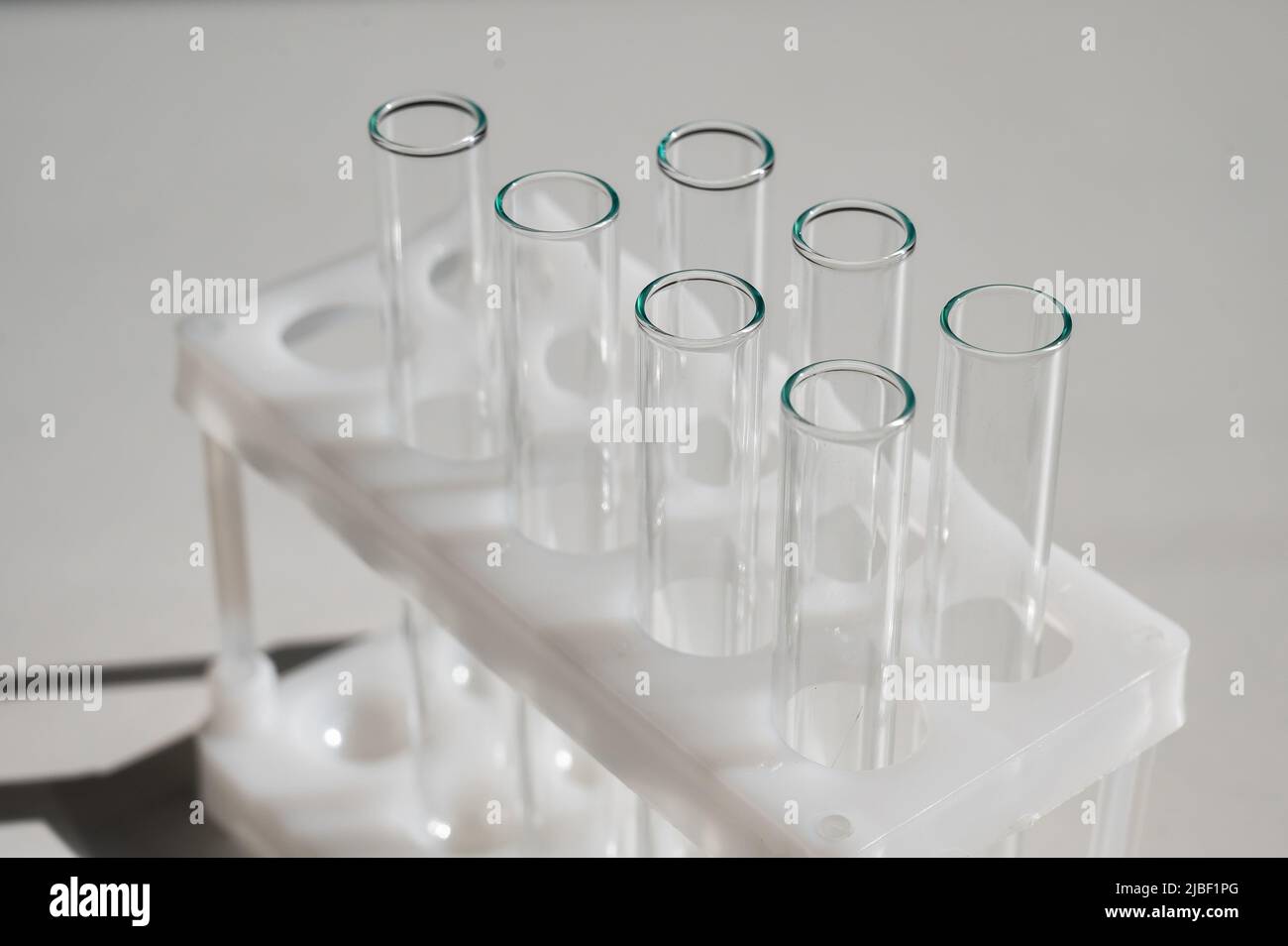 Empty test tubes in a rack on a white background Stock Photo - Alamy