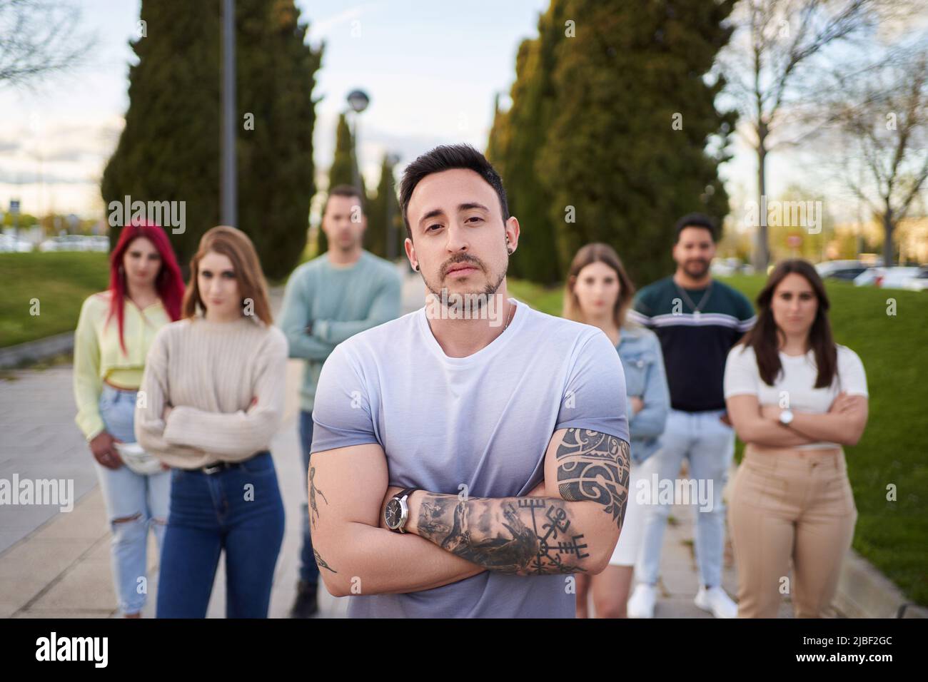 Man looking serious at the camera while standing in front of a group of ...