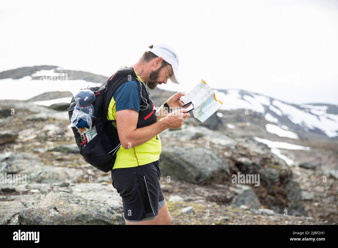 Mature man looking at map and compass on mountain Stock Photo - Alamy