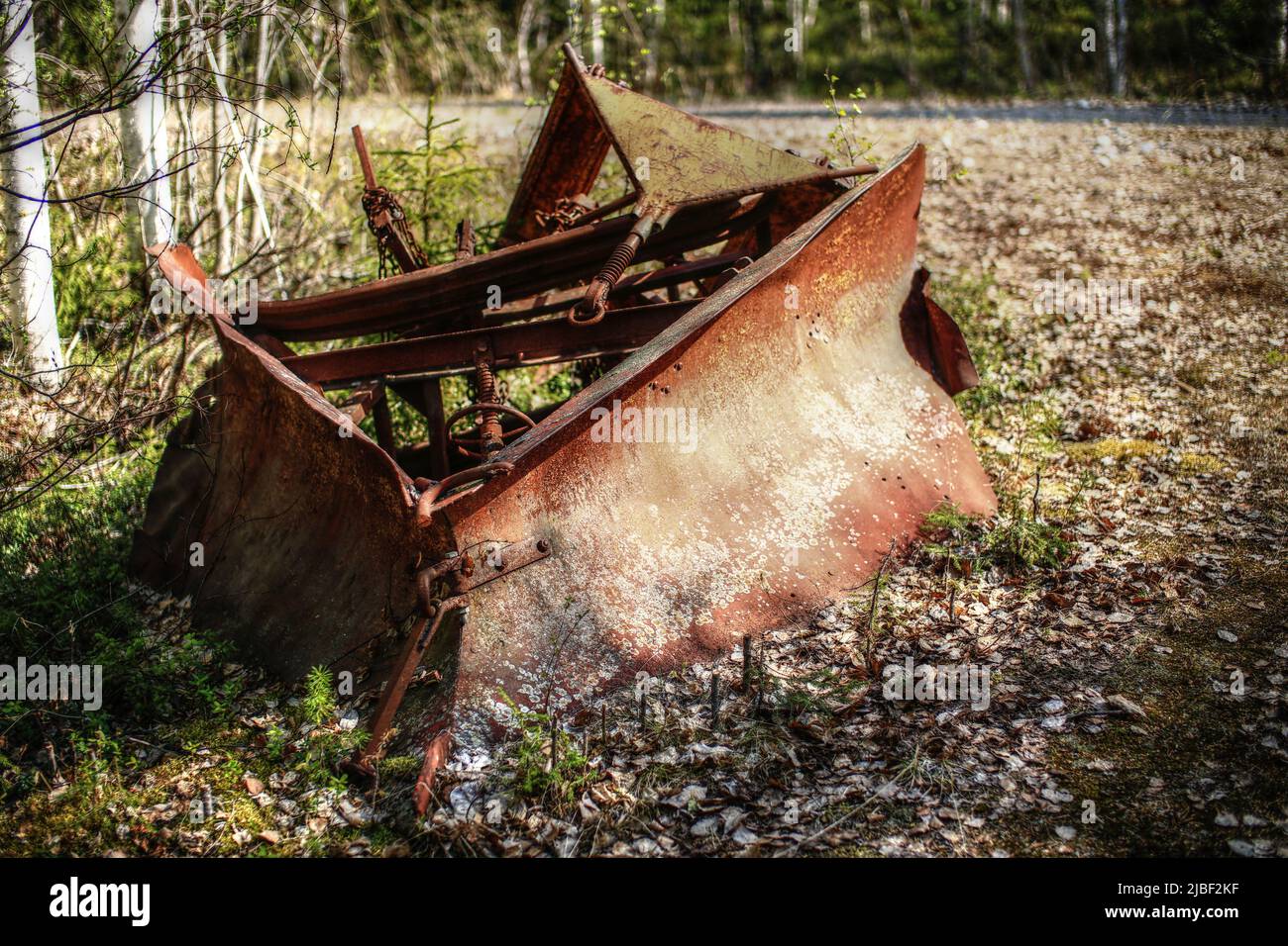 Historic rusty snow plow lying in the forest Stock Photo - Alamy