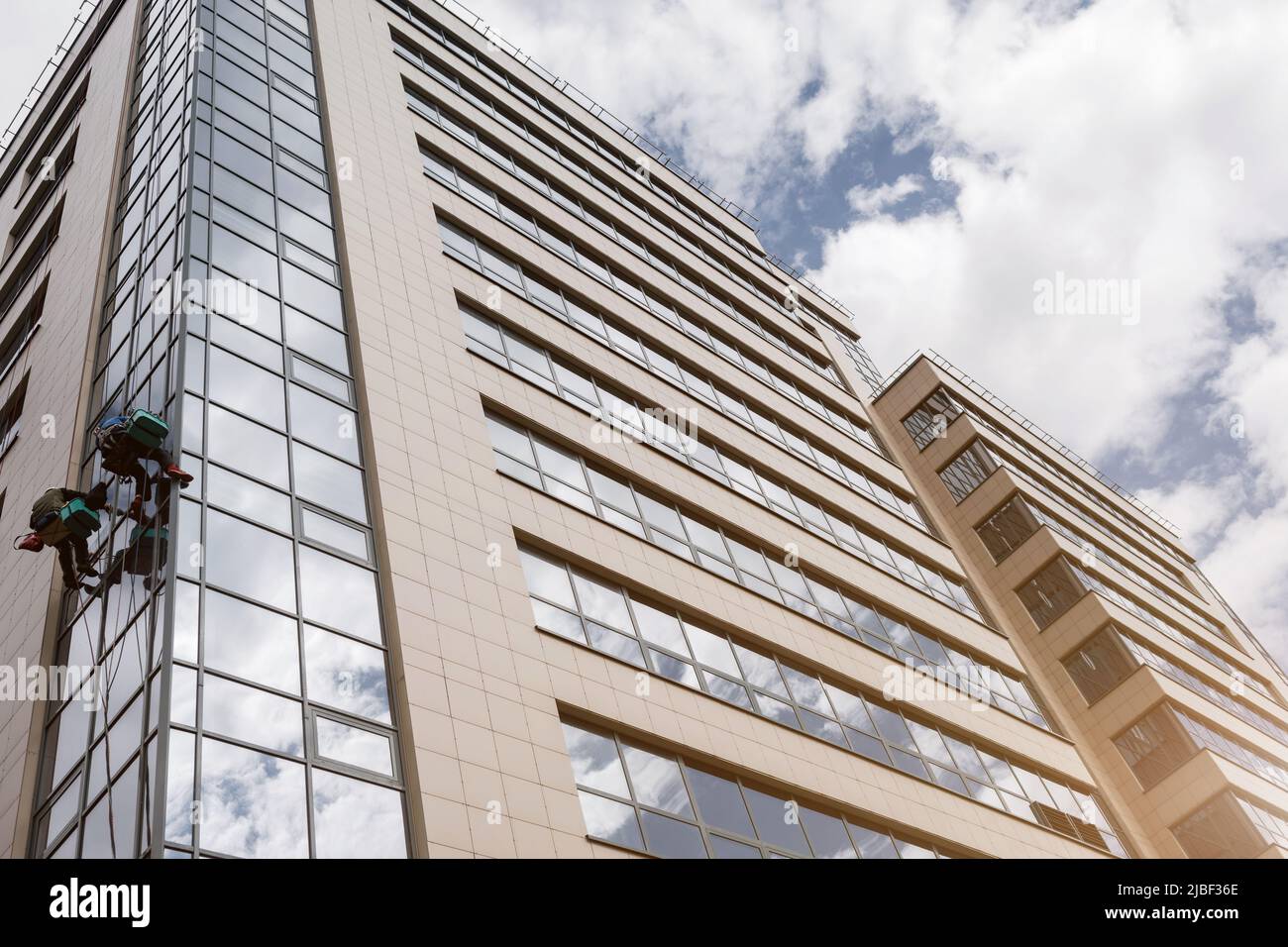two men cleaning windows on a high rise building Stock Photo - Alamy