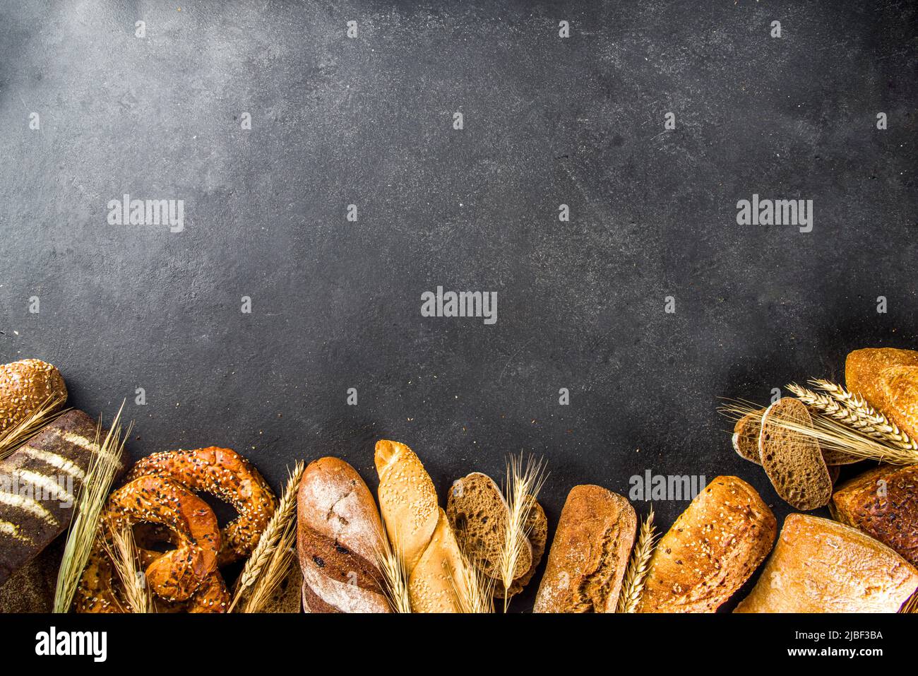 Assortment of various delicious freshly baked bread, on black concrete ...