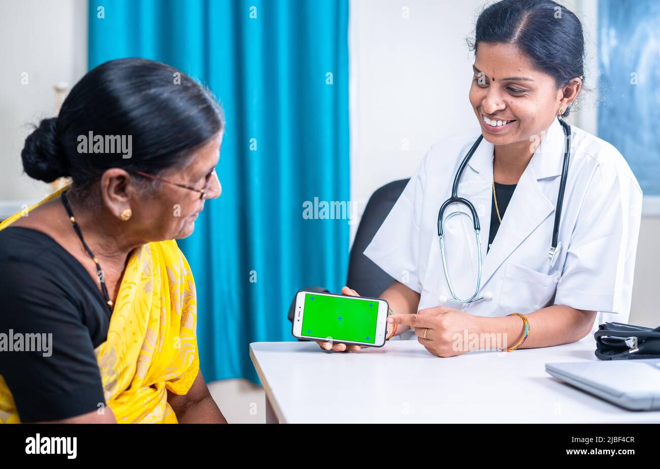 Doctor at hospital explaining or assisting senior woman patient by ...
