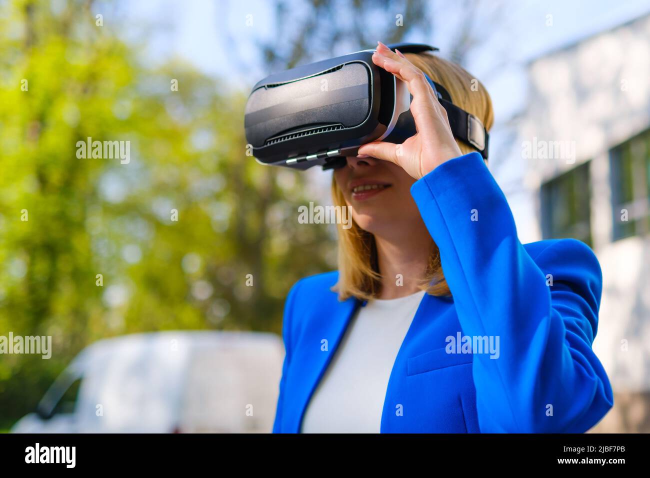 Woman with VR virtual reality goggles experiences a metaverse world ...