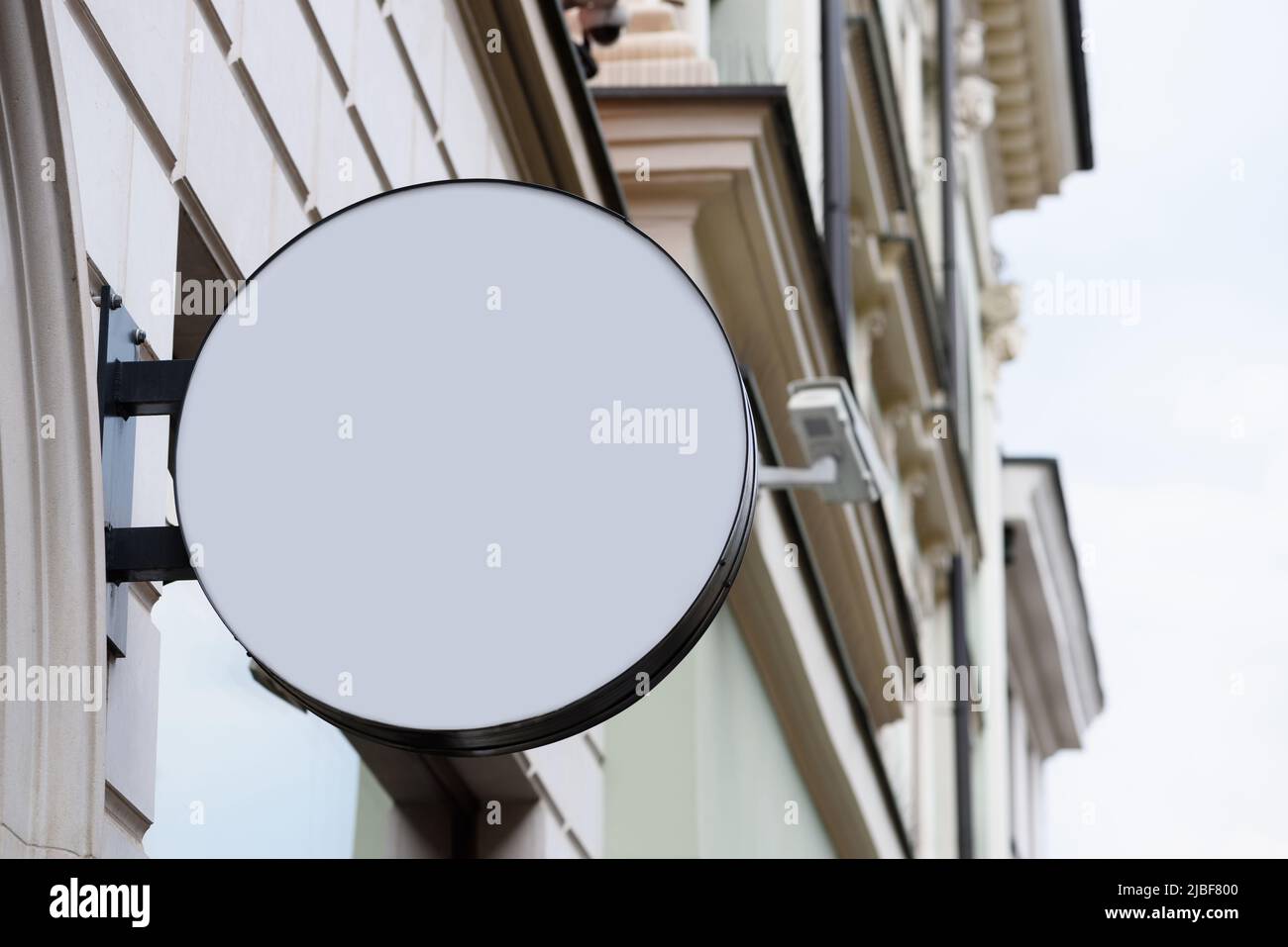 Blank metal circle store signboard on street hanging mounted on the ...