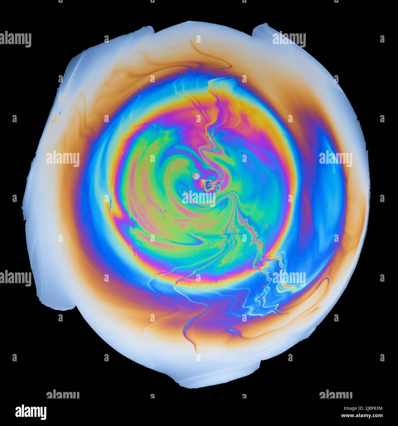 Interference colors from an oil film on water isolated on black ...
