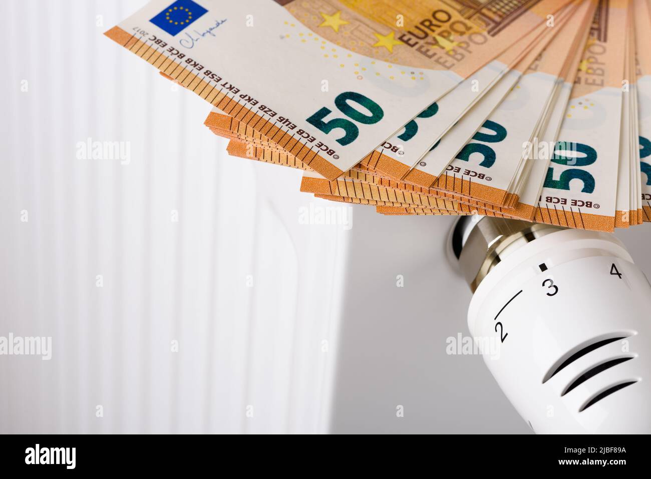 Euro money banknotes on heating radiator battery with thermostat ...