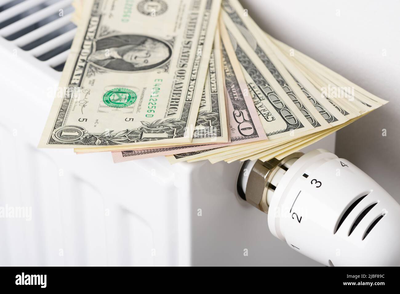 Dollar money banknotes on heating radiator battery with thermostat ...
