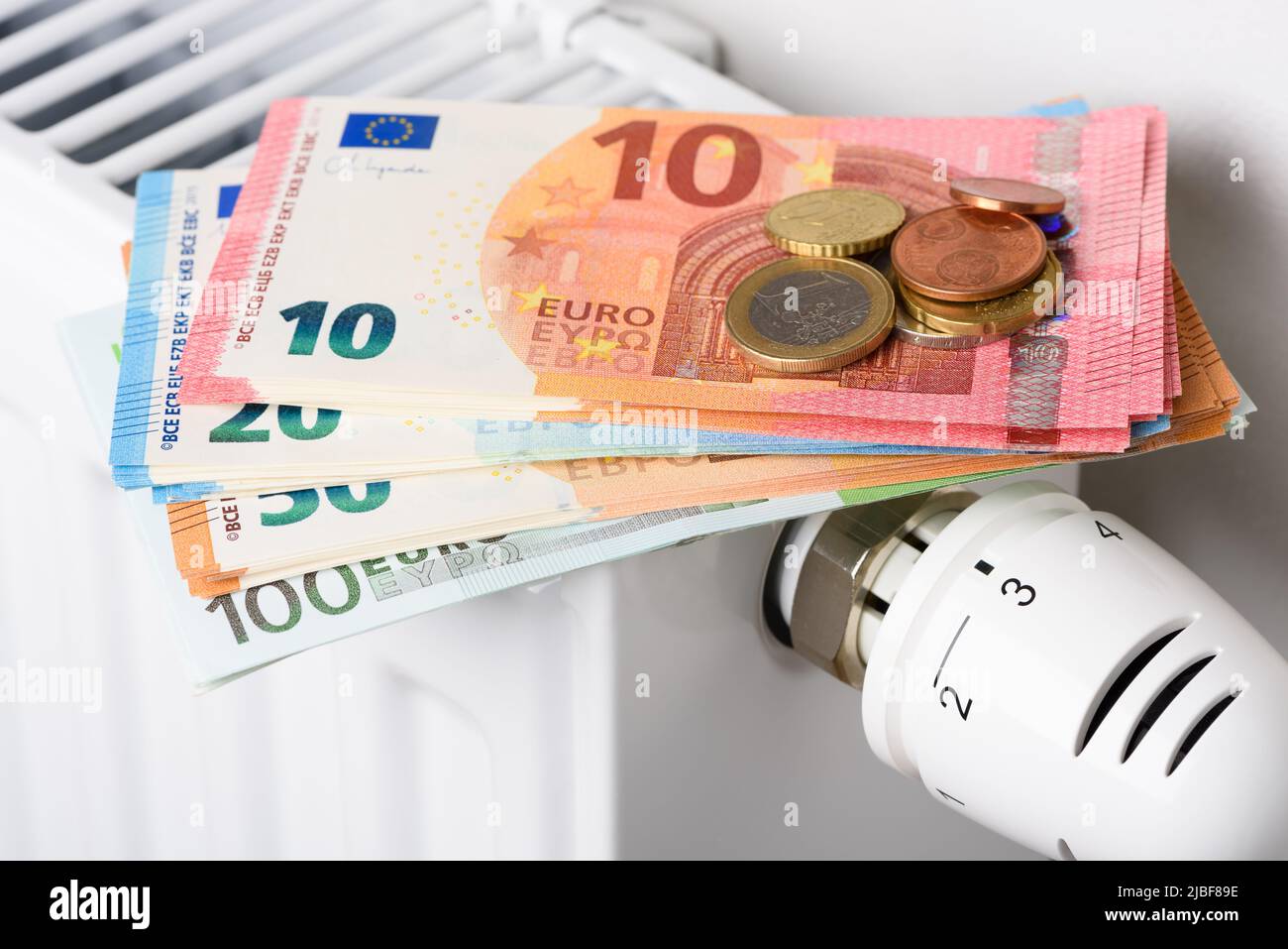 Euro money banknotes on heating radiator battery with thermostat ...