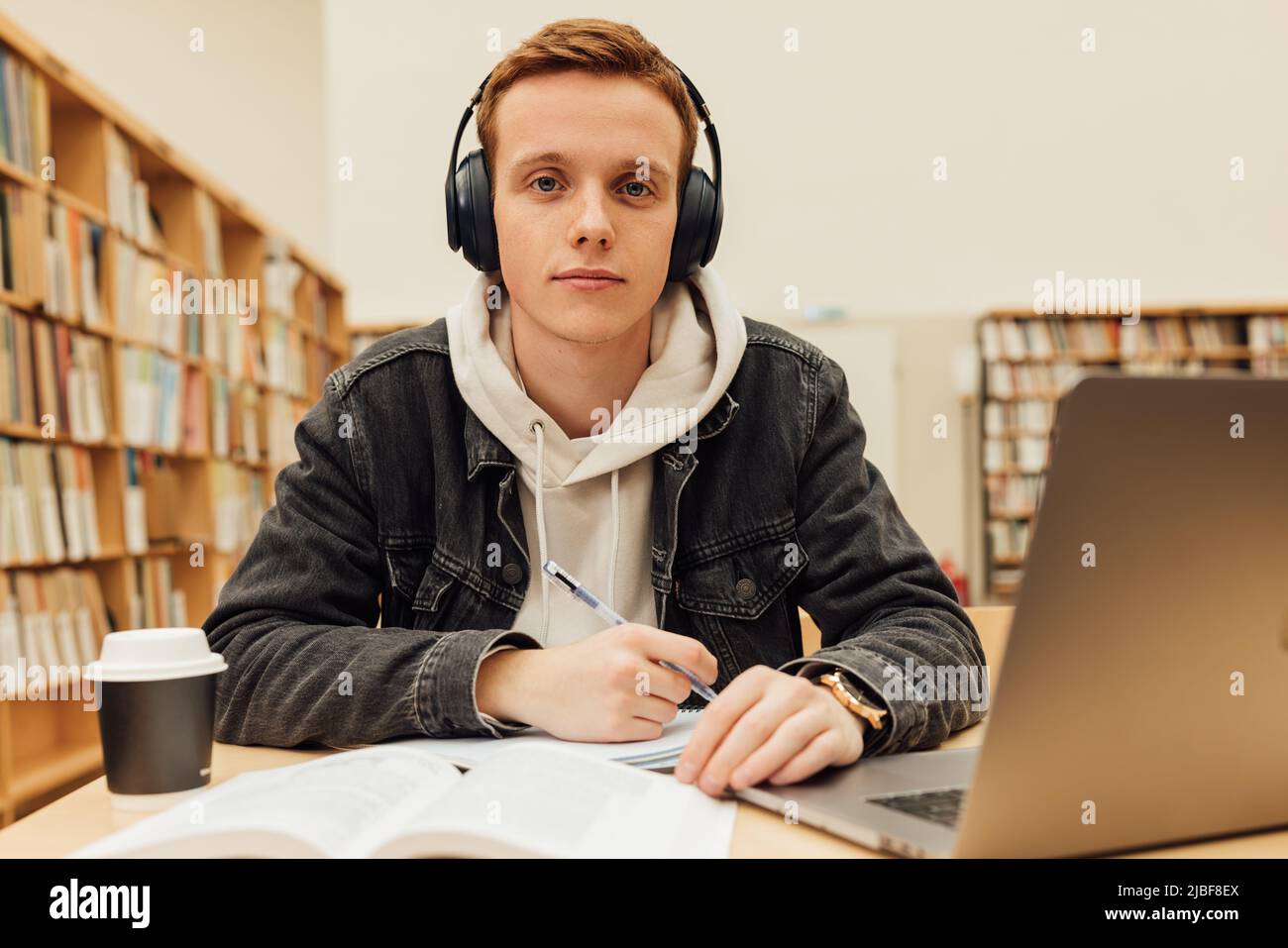 Handsome male student in a university library. Young man studying on ...