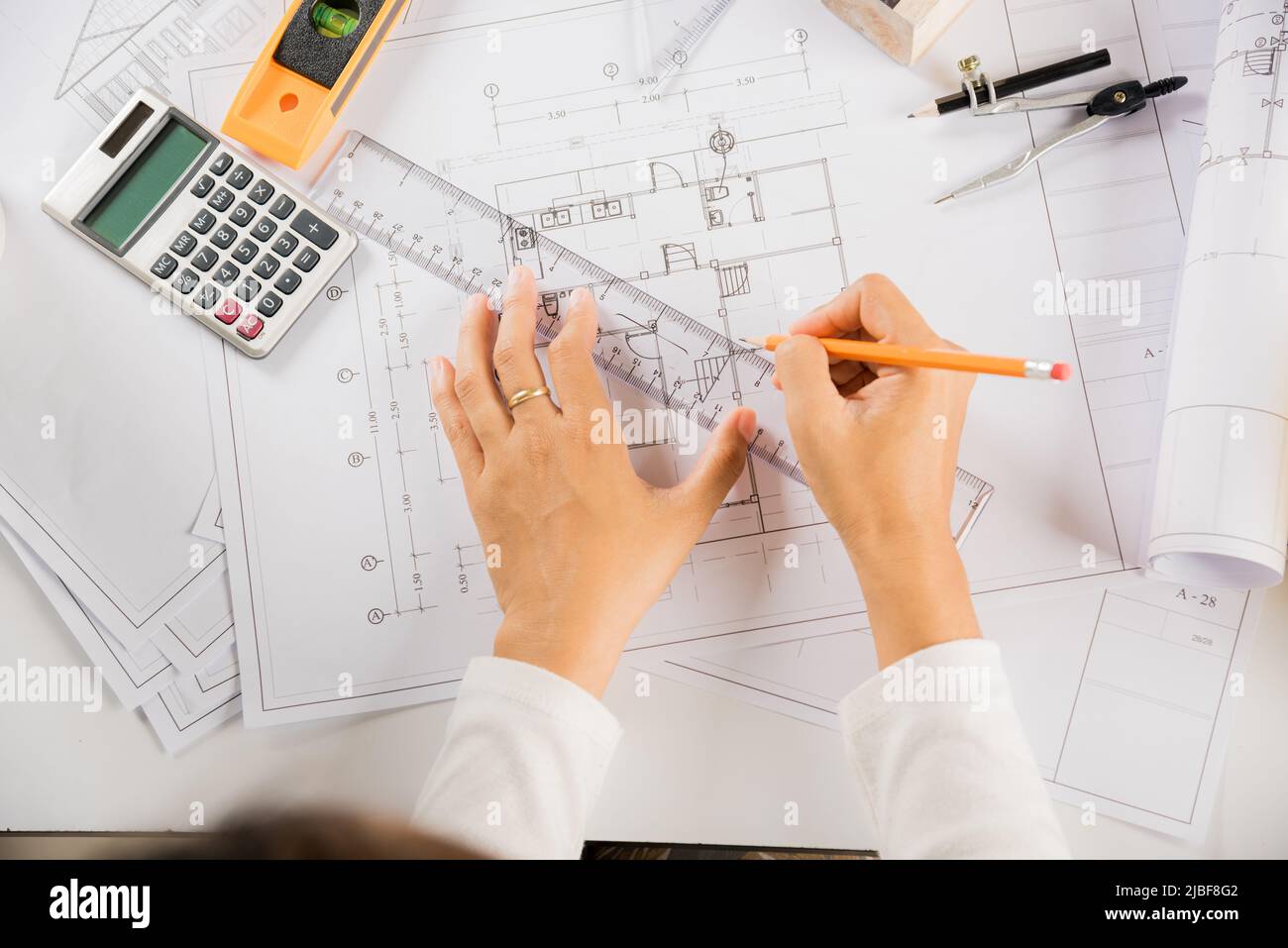 Architectural project workplace. Architect drawing with ruler on house ...