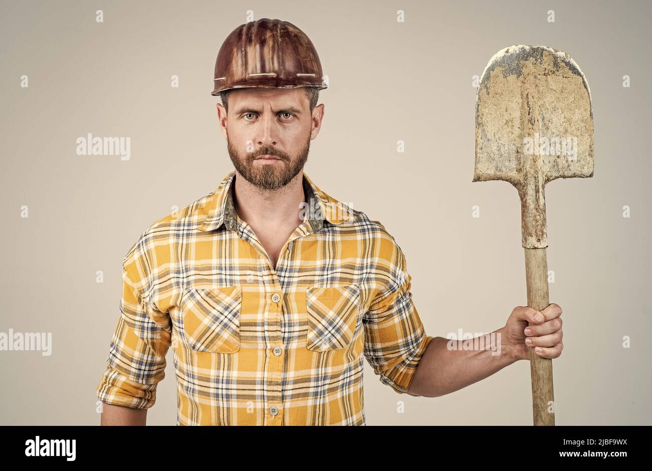 man laborer in construction safety helmet and checkered shirt on ...