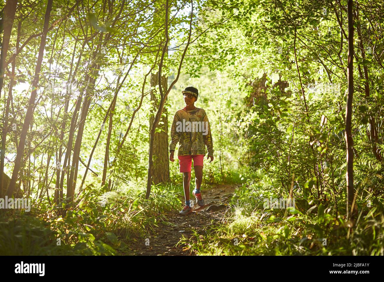 Boy walking on path in forest Stock Photo - Alamy