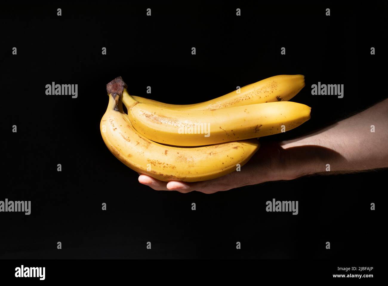 Hand holds bunch of bananas hi-res stock photography and images - Alamy