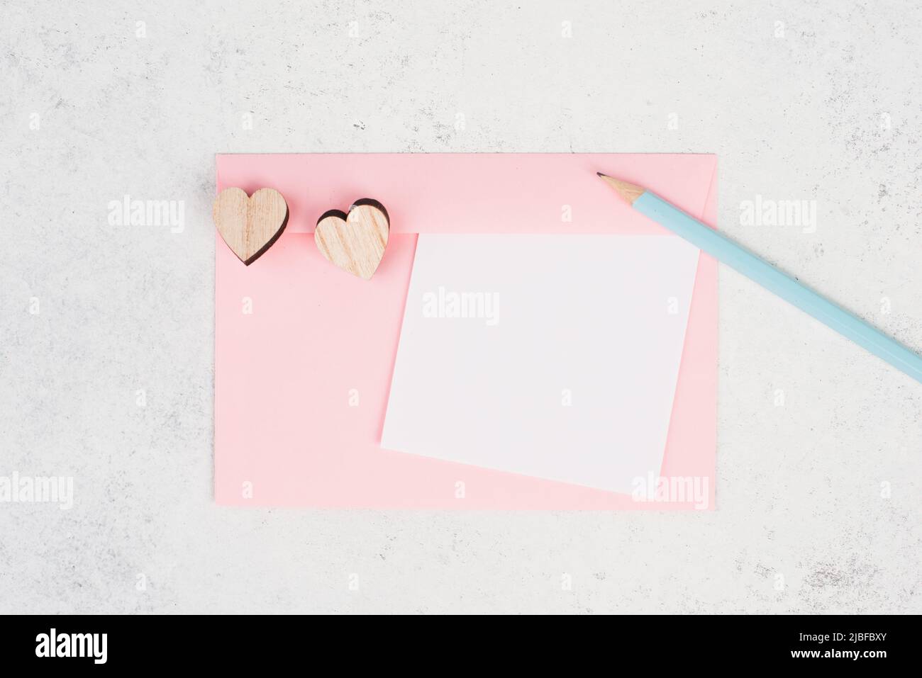 Pink envelope with hearts, empty copy space, blue pencil, valintines ...