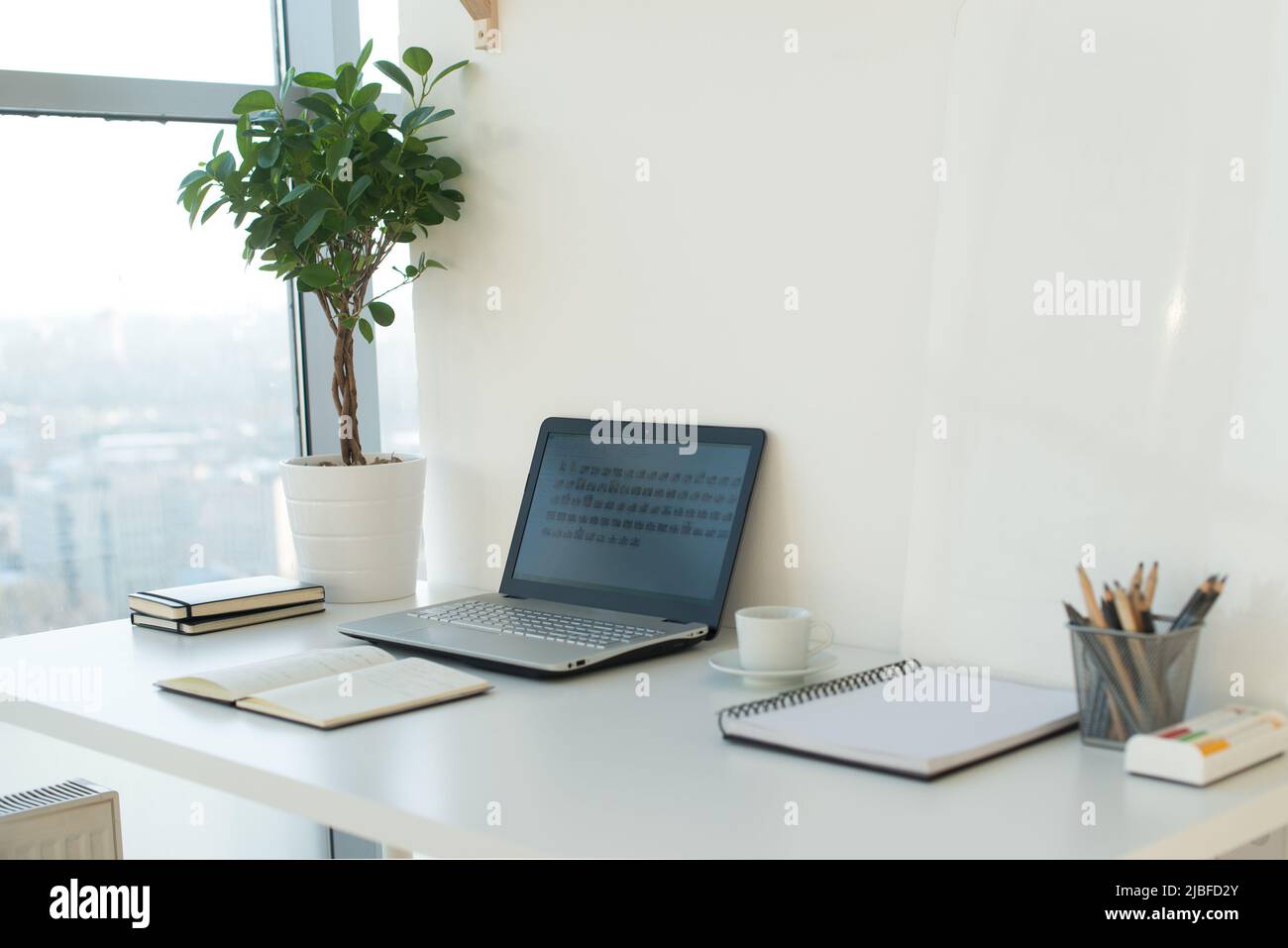 Side view picture of studio workplace with blank notebook, laptop ...