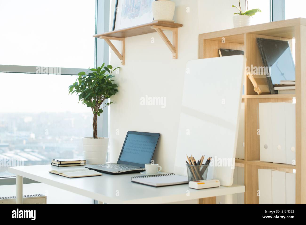 Side view picture of studio workplace with blank notebook, laptop ...