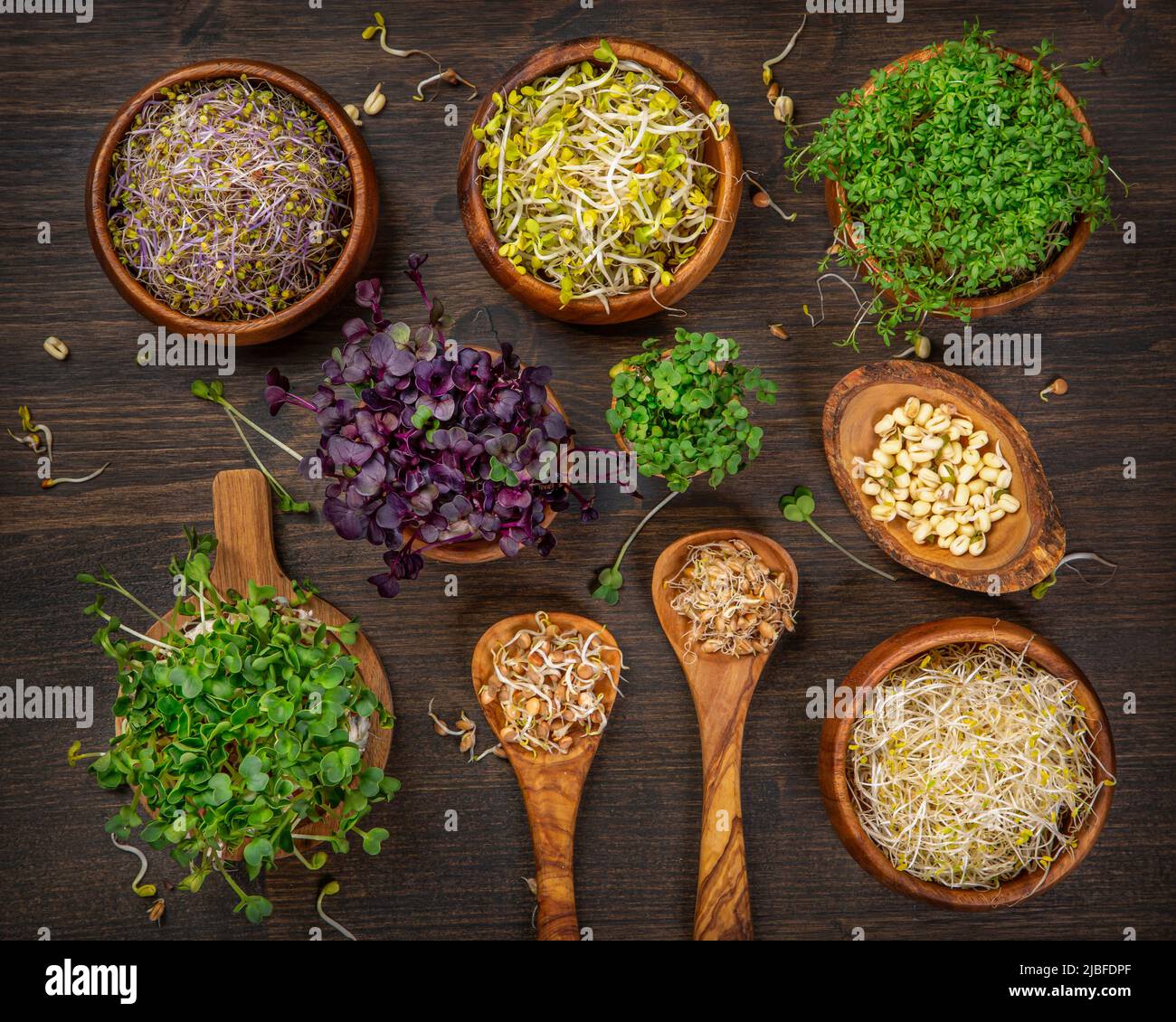 Different types of microgreens on a wooden background Stock Photo - Alamy
