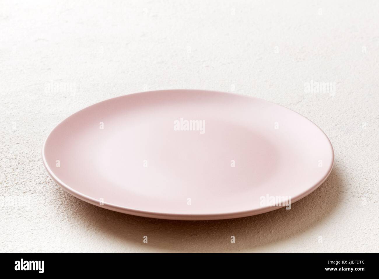 Perspective view of empty pink plate on cement background. Empty space ...