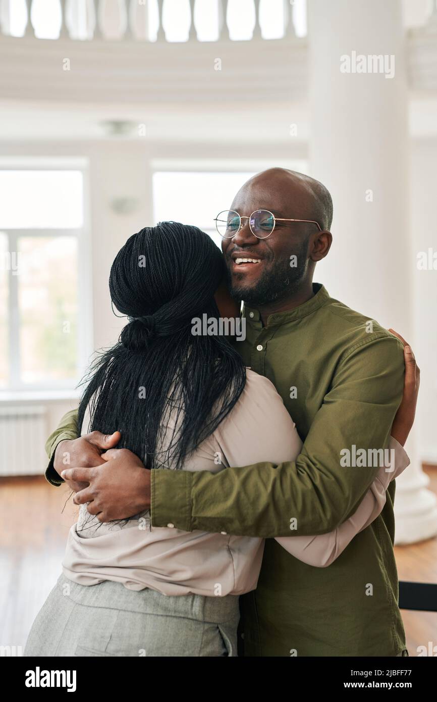 Young smiling black man giving hug to worried or unhappy African ...