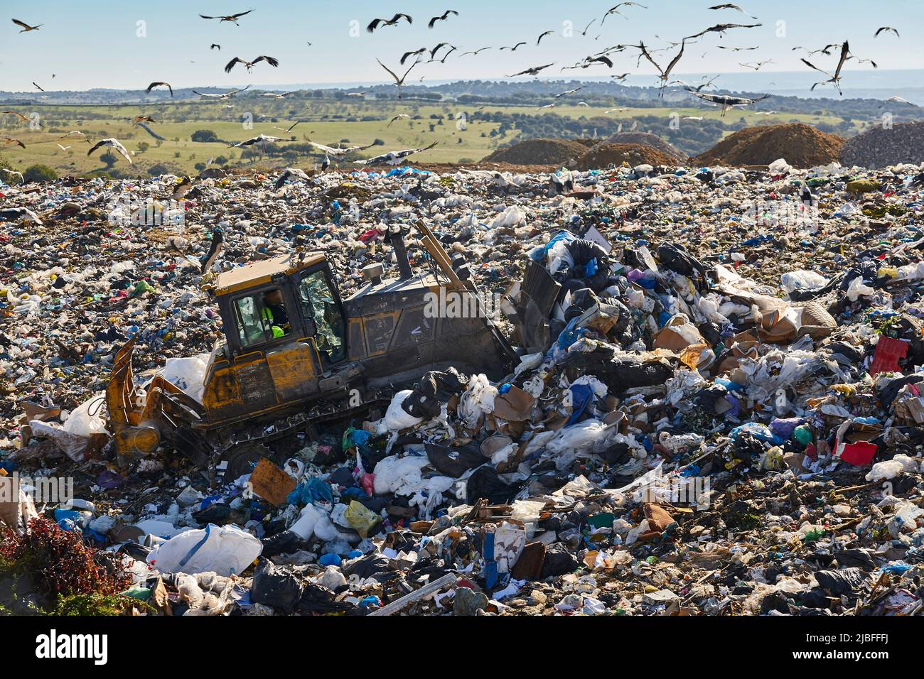 Heavy machinery shredding garbage in an open air landfill. Waste Stock ...