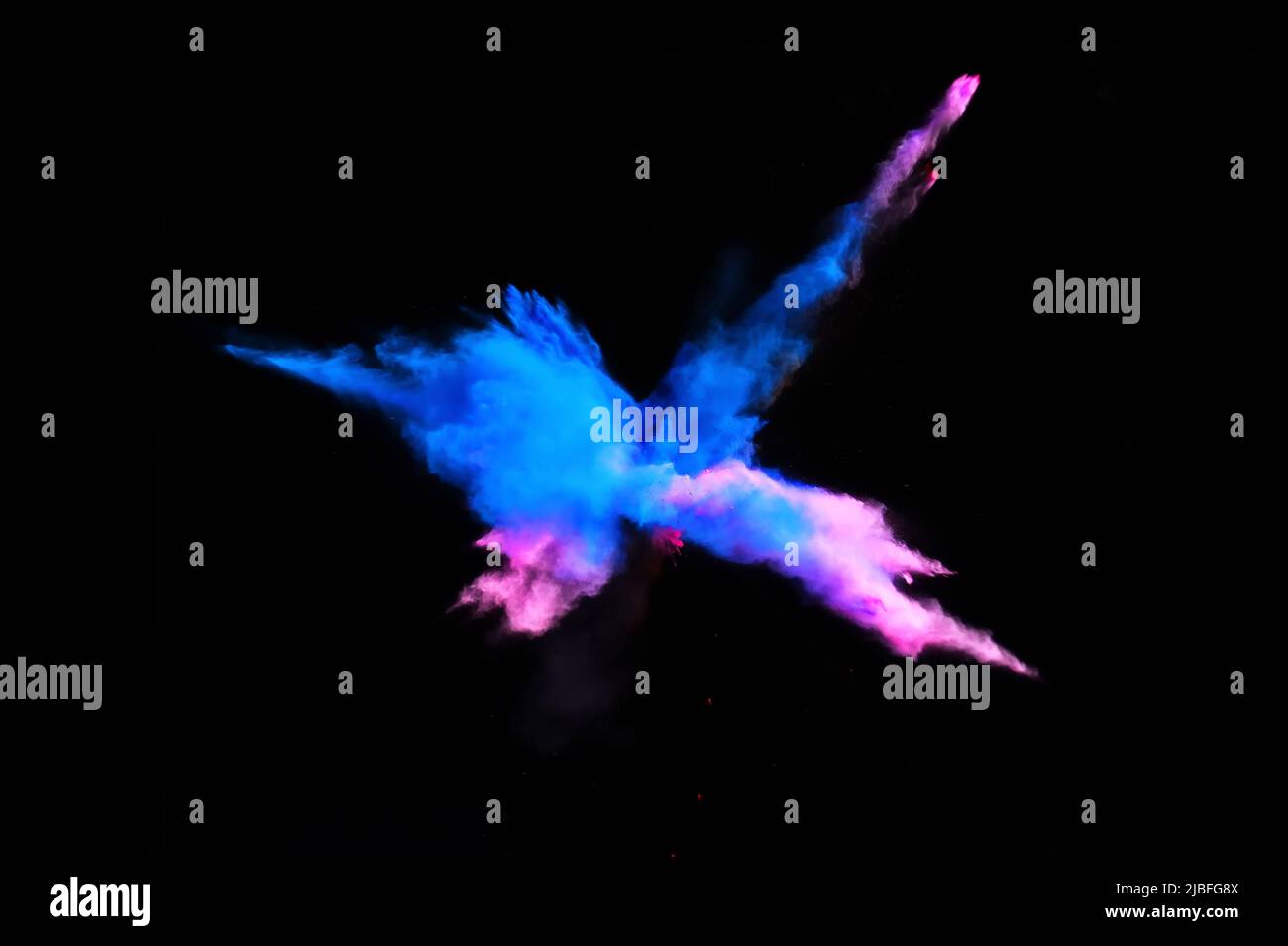 Various multicolored forms of powder paint explode in front of a black ...