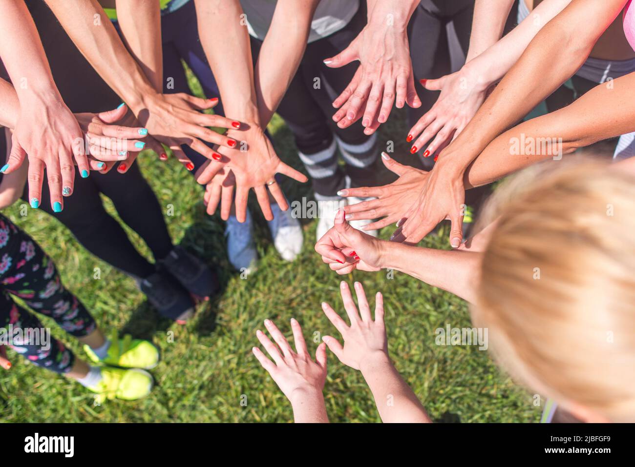 Group of fit women putting their hands together Stock Photo - Alamy