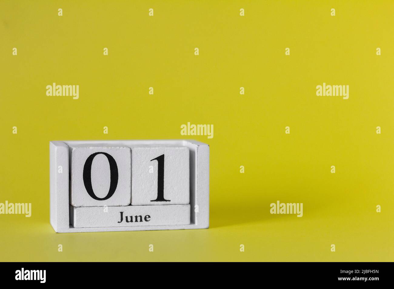 June 1 on a wooden calendar on a yellow background. The first day of ...