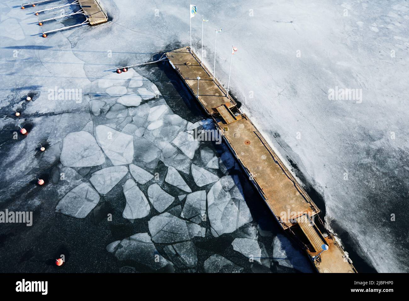 Pier in frozen harbour with ice Stock Photo - Alamy