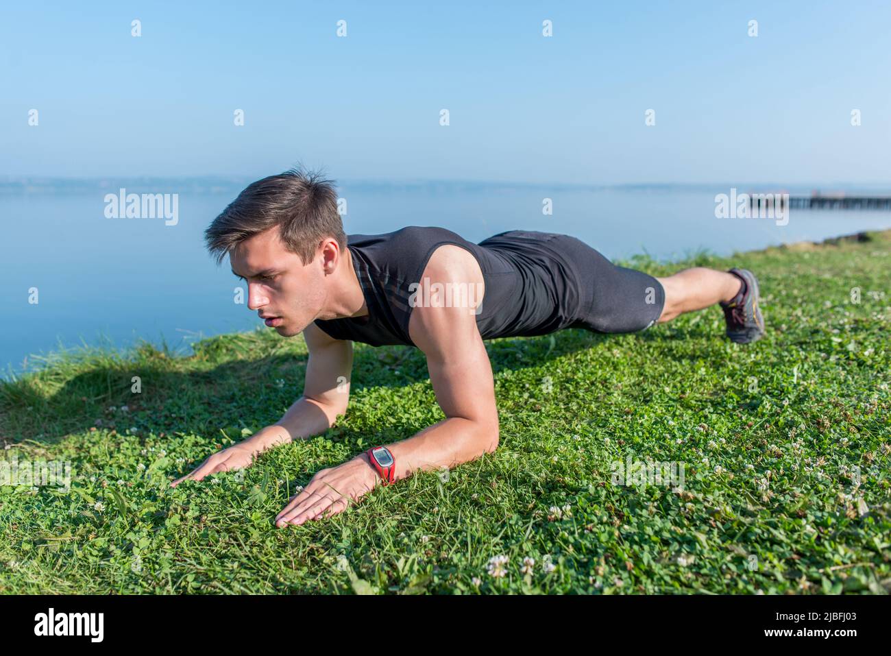 Fit man doing plank core exercise working on abdominal back muscles ...