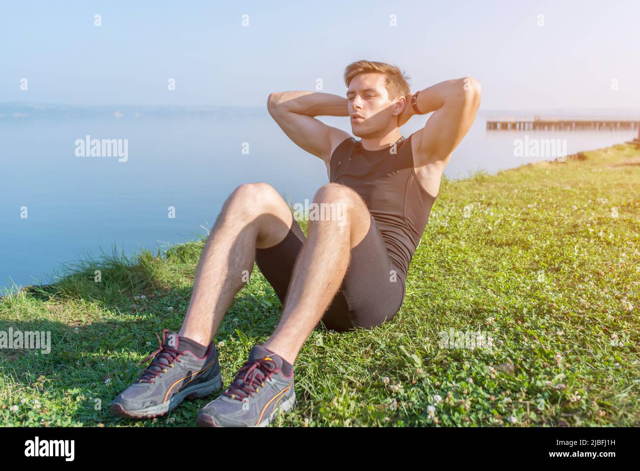 Sporty young man doing sit-ups abs crunches in nature Stock Photo - Alamy