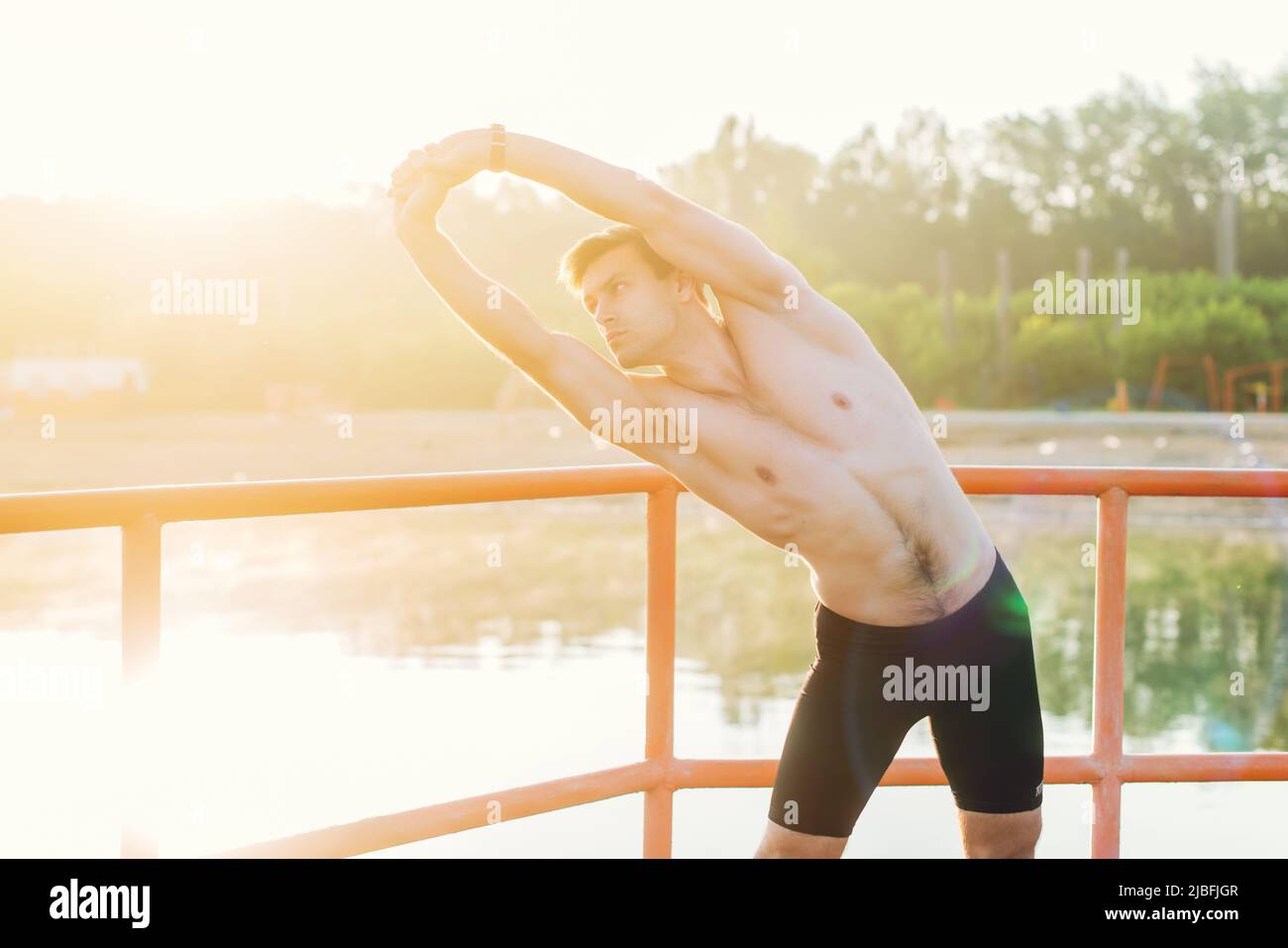 Young athlete man doing side bend exercise Stock Photo - Alamy