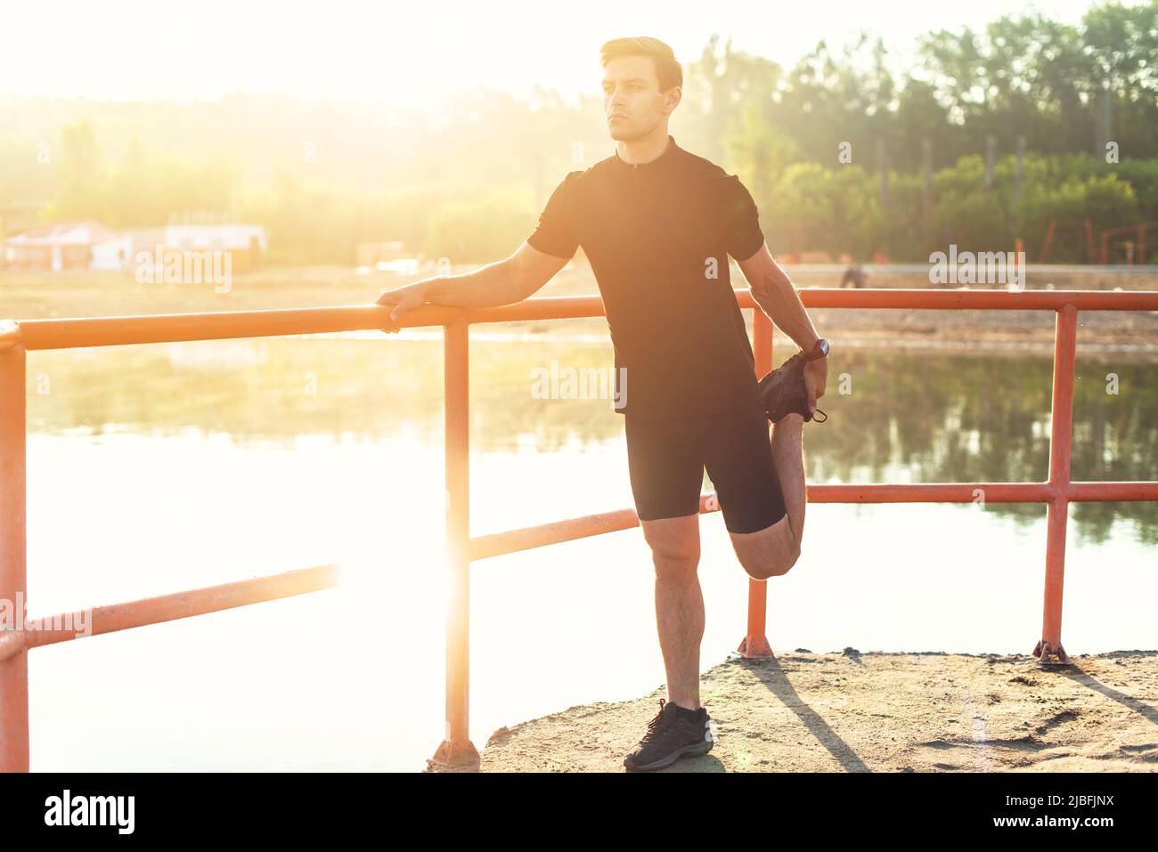 Fit young man preparation for running workout. Jogger stretching his ...