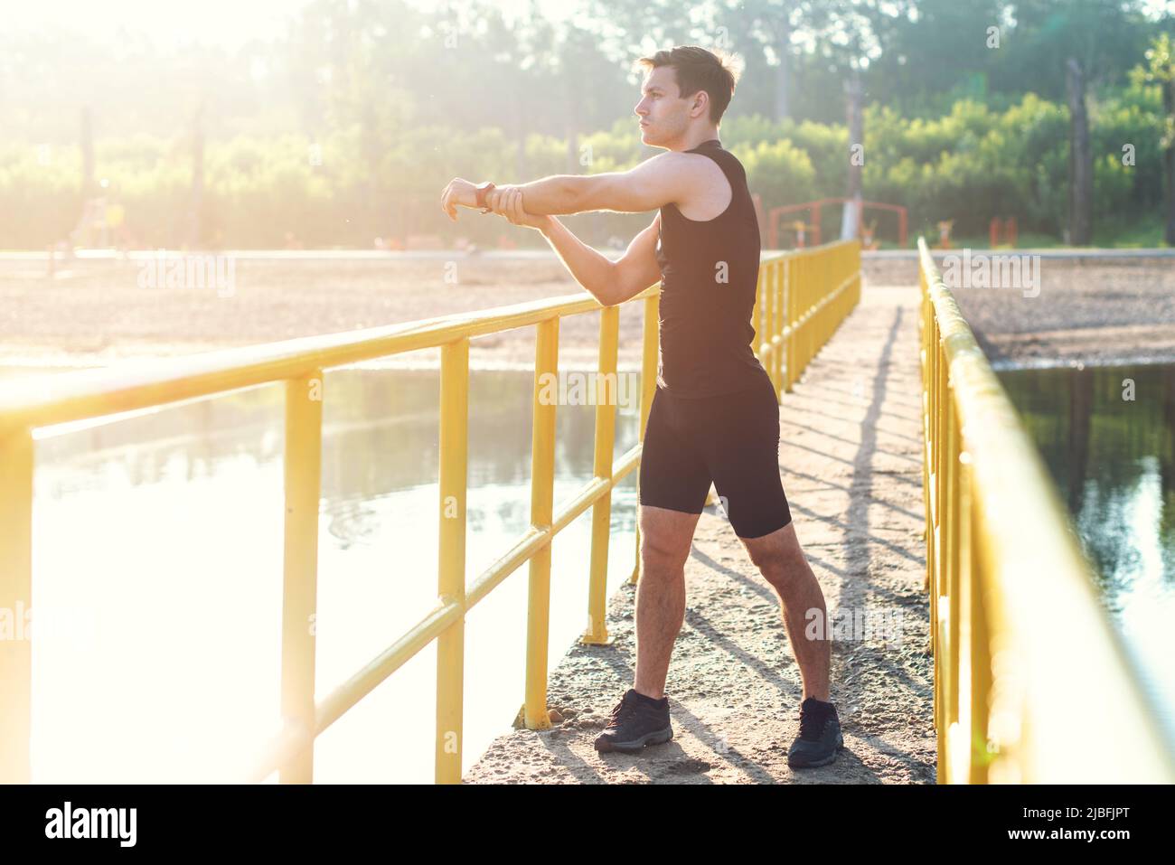 Fitness man stretching arms, shoulder. Runner warming up and exercising ...